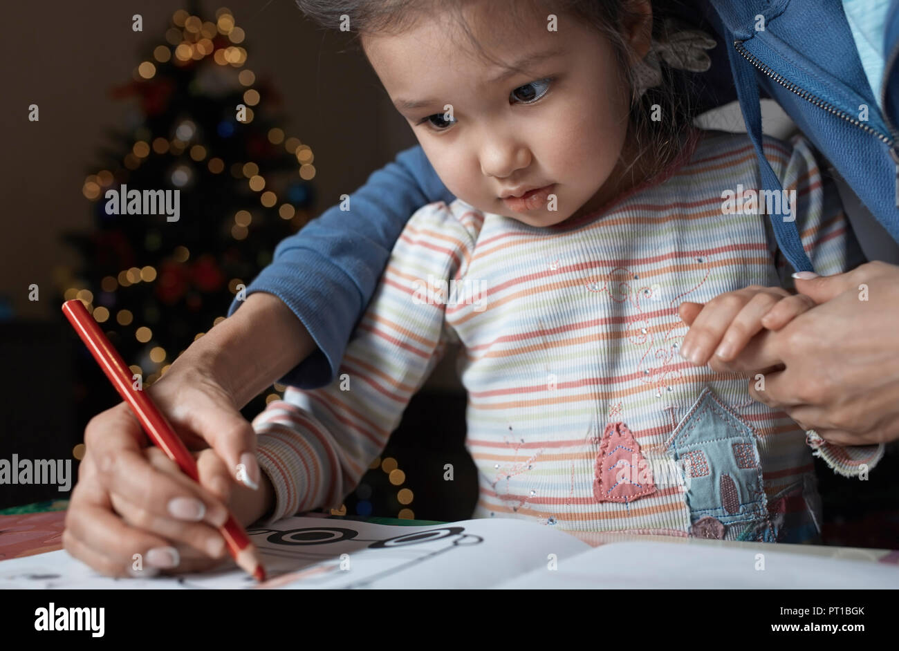 Mother helping her little daughter to draw Stock Photo - Alamy