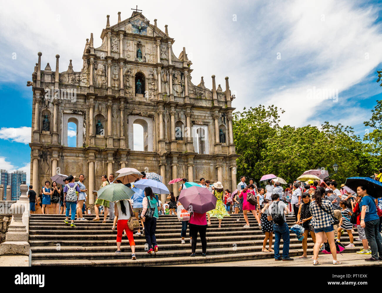 Macau, China - JULY 11, 2014: A big crowd of tourists with umbrellas in ...