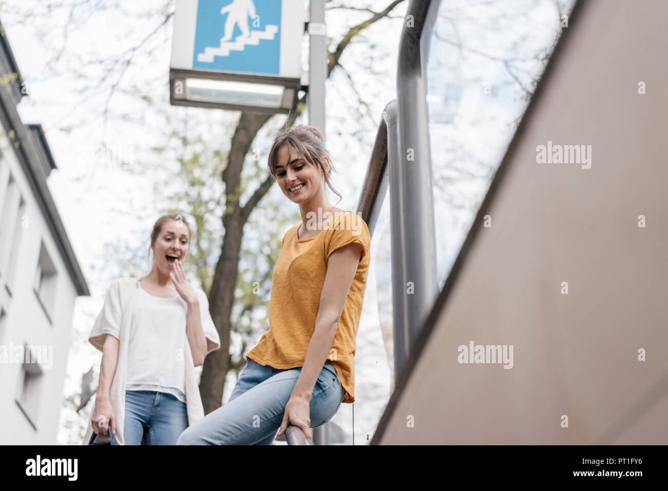 Girlfriends having fun in the city, sliding on railing of underpass Stock Photo - Alamy