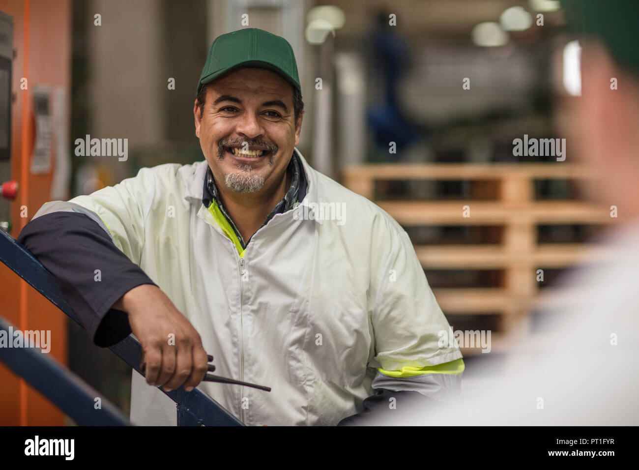 Worker smiling in factory Stock Photo - Alamy