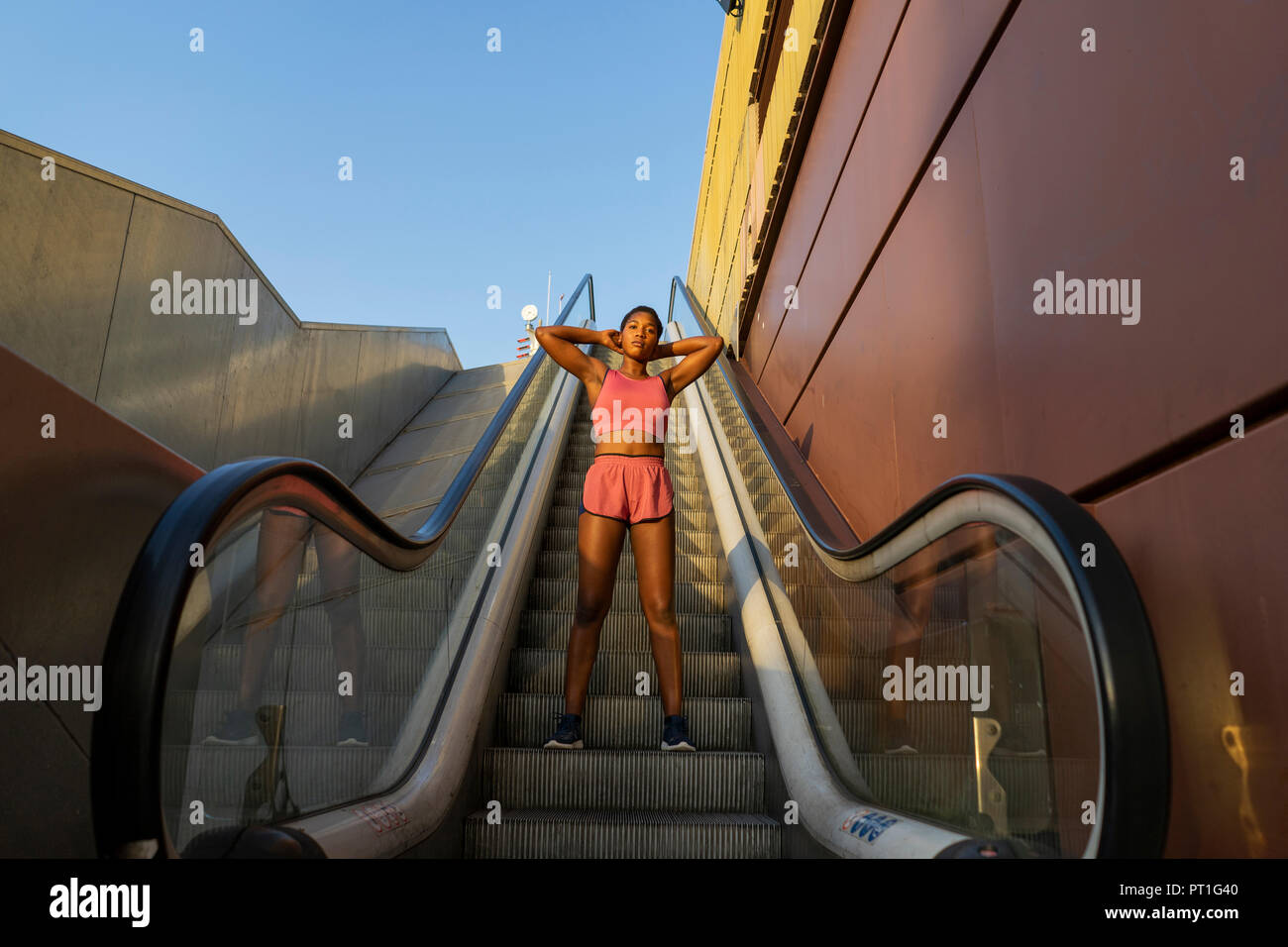 Young sportive woman on escalator Stock Photo - Alamy