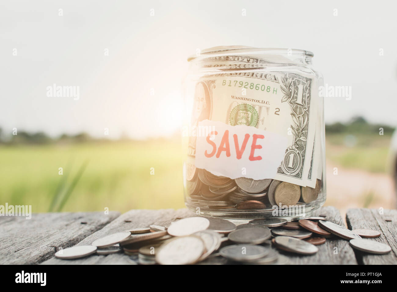 Save money concept, coins stacked and jar Stock Photo - Alamy
