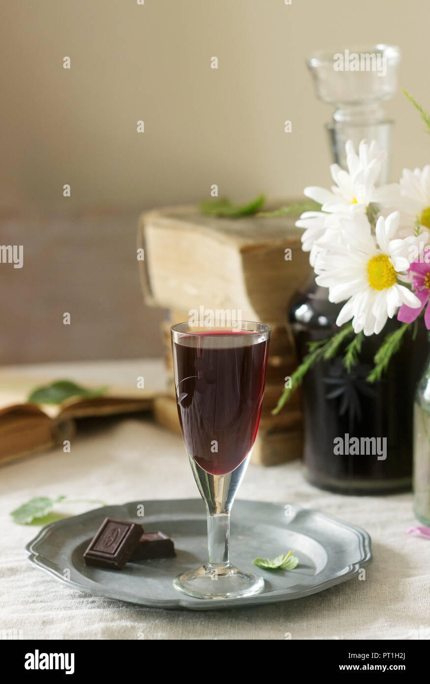 Cream de Cassis homemade blackcurrant liqueur in small glasses, books ...