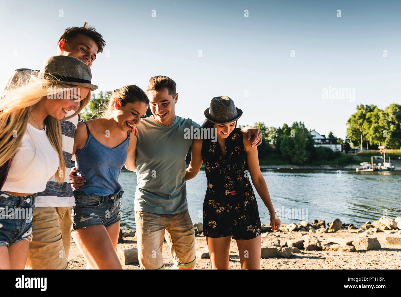 Group of happy friends arm in arm at the riverside Stock Photo - Alamy