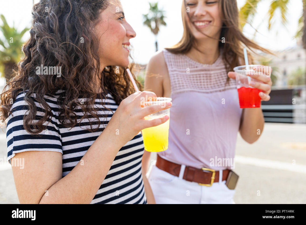 Two happy female friends enjoying a fresh slush Stock Photo - Alamy