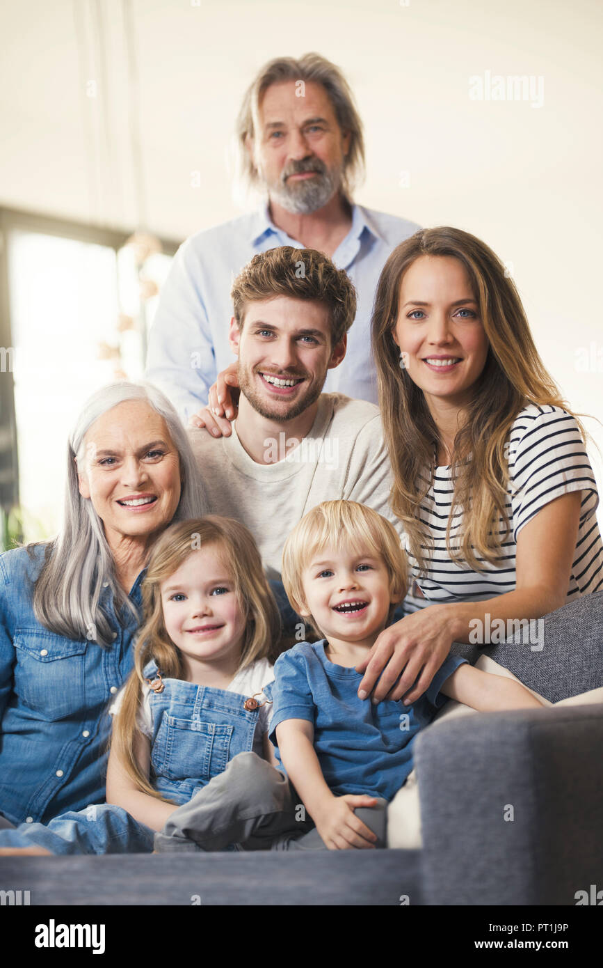 Extended family sitting on couch, smiling happily Stock Photo - Alamy