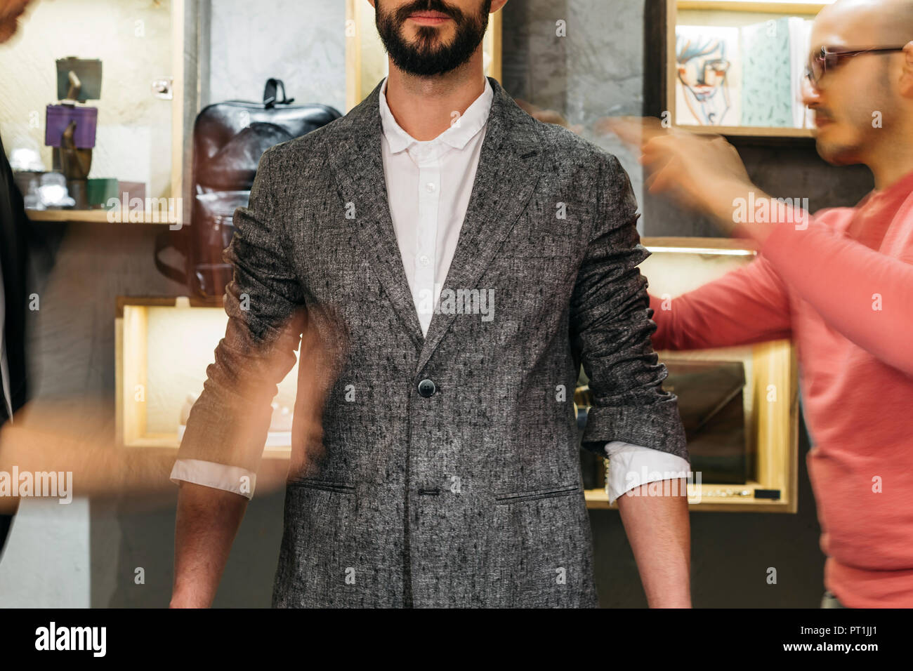 Two men working on new stylish look for handsome man in showroom Stock ...