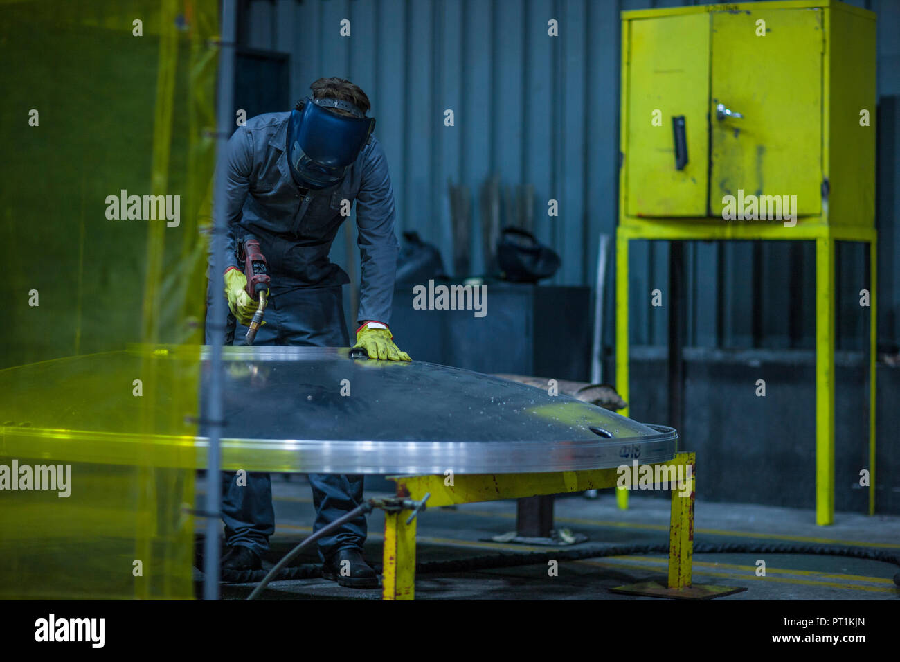 Worker welding in factory Stock Photo - Alamy