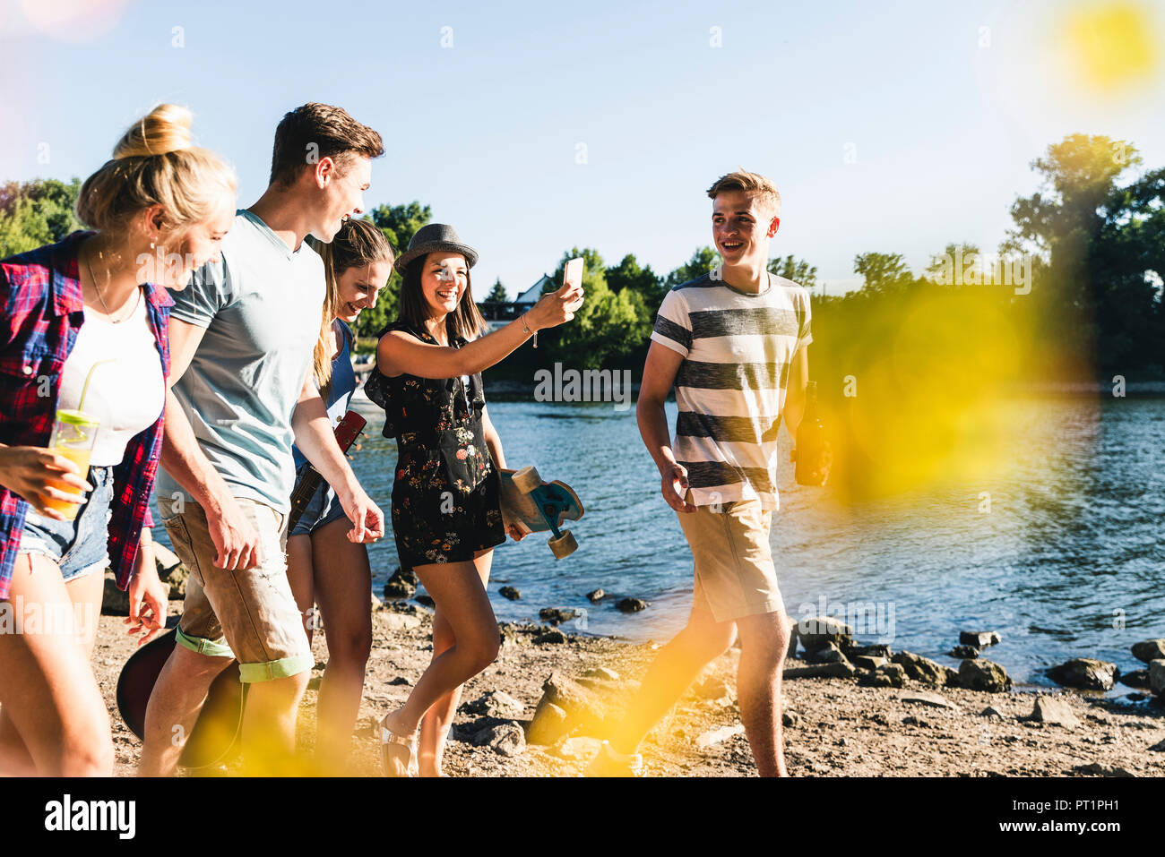 Group of happy friends walking at the riverside Stock Photo - Alamy