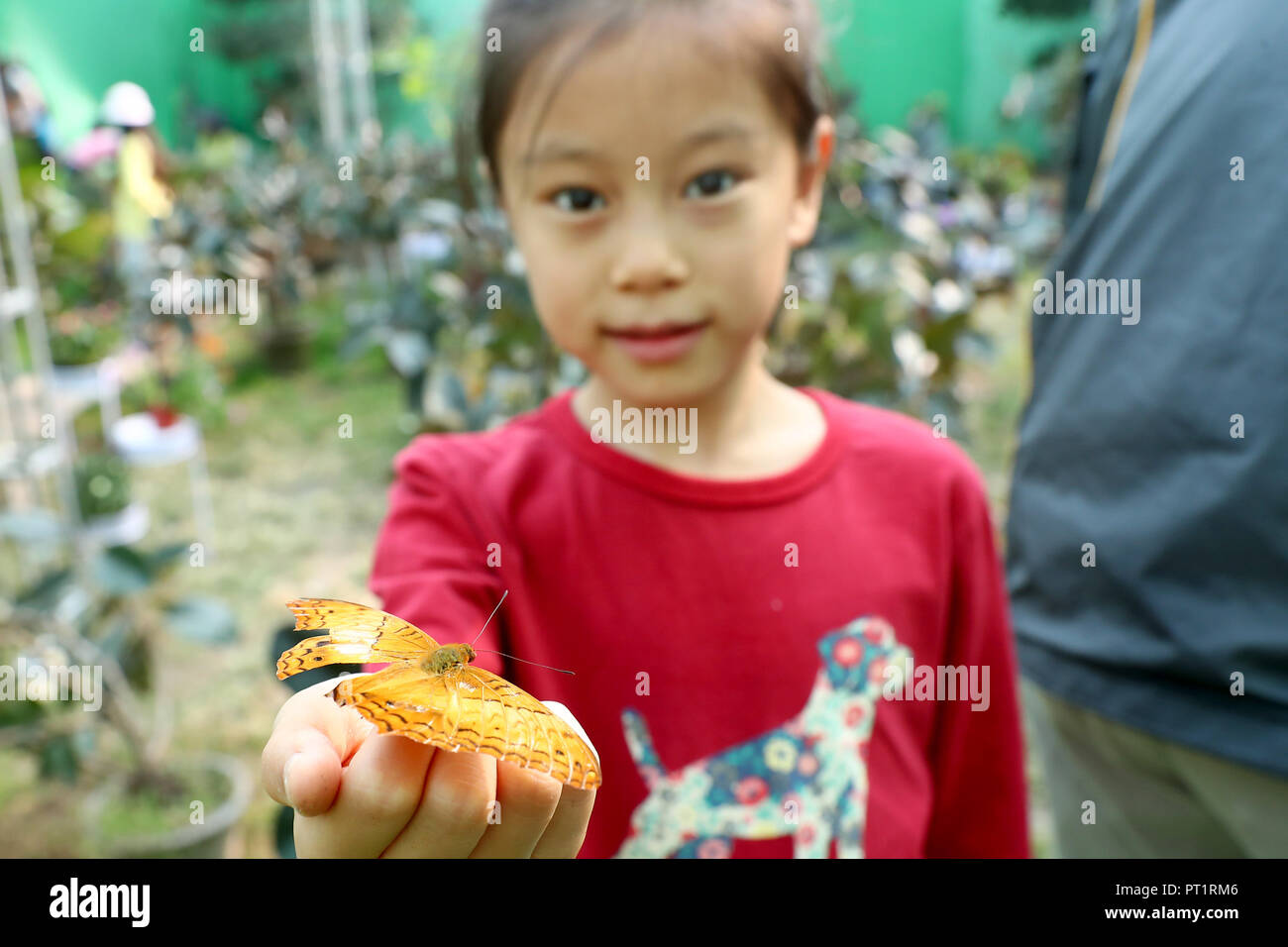 Beijing, China. 5th Oct, 2018. A girl plays with a butterfly at the ...
