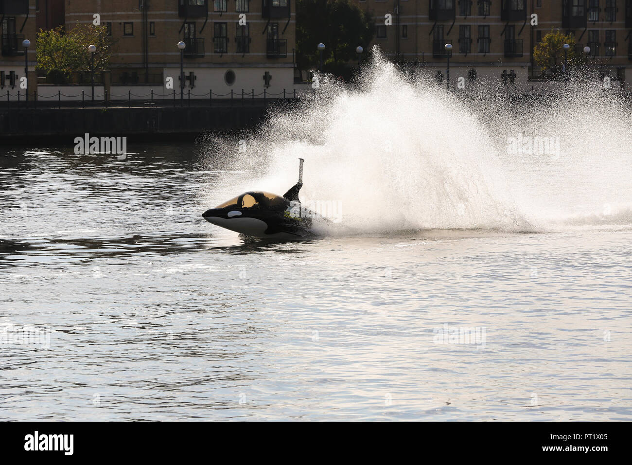 London's Royal Docks. UK 5 Oct 2018 - Man riding a whale shaped jet-ski ...