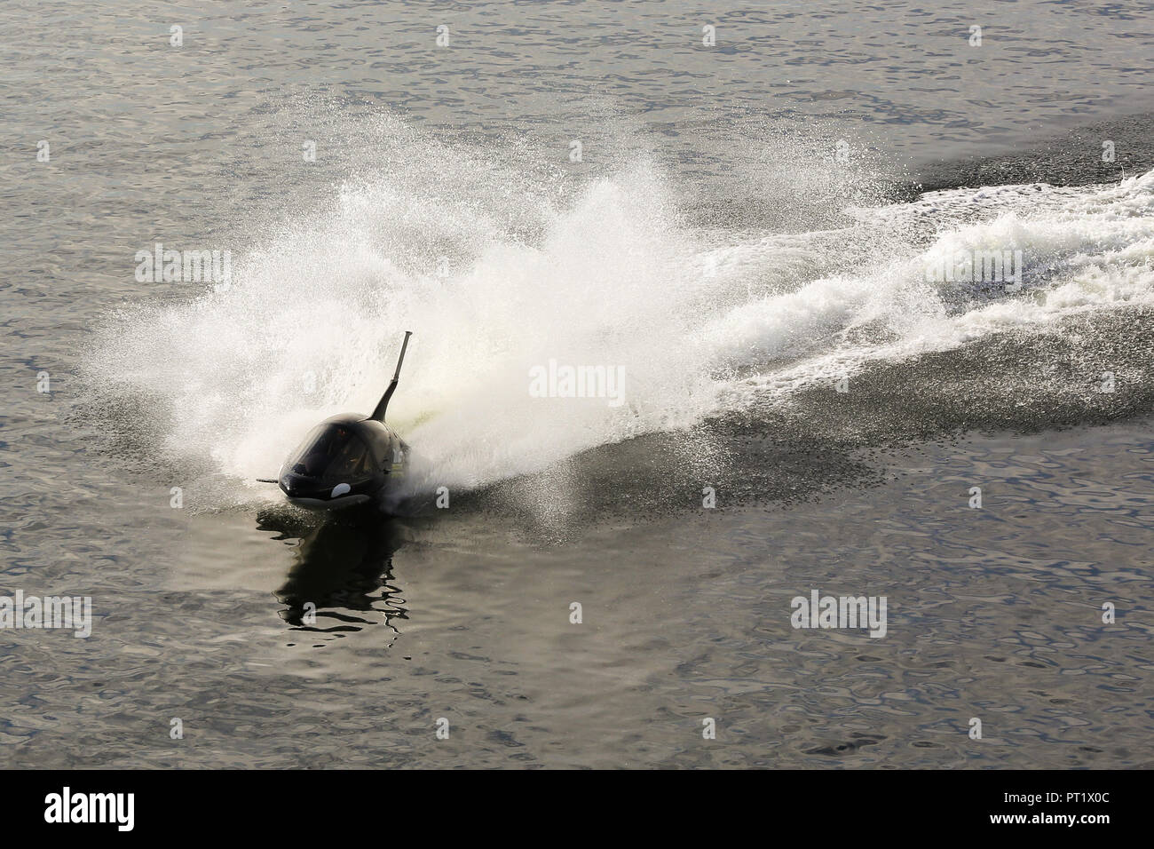 London's Royal Docks. UK 5 Oct 2018 - Man riding a whale shaped jet-ski ...