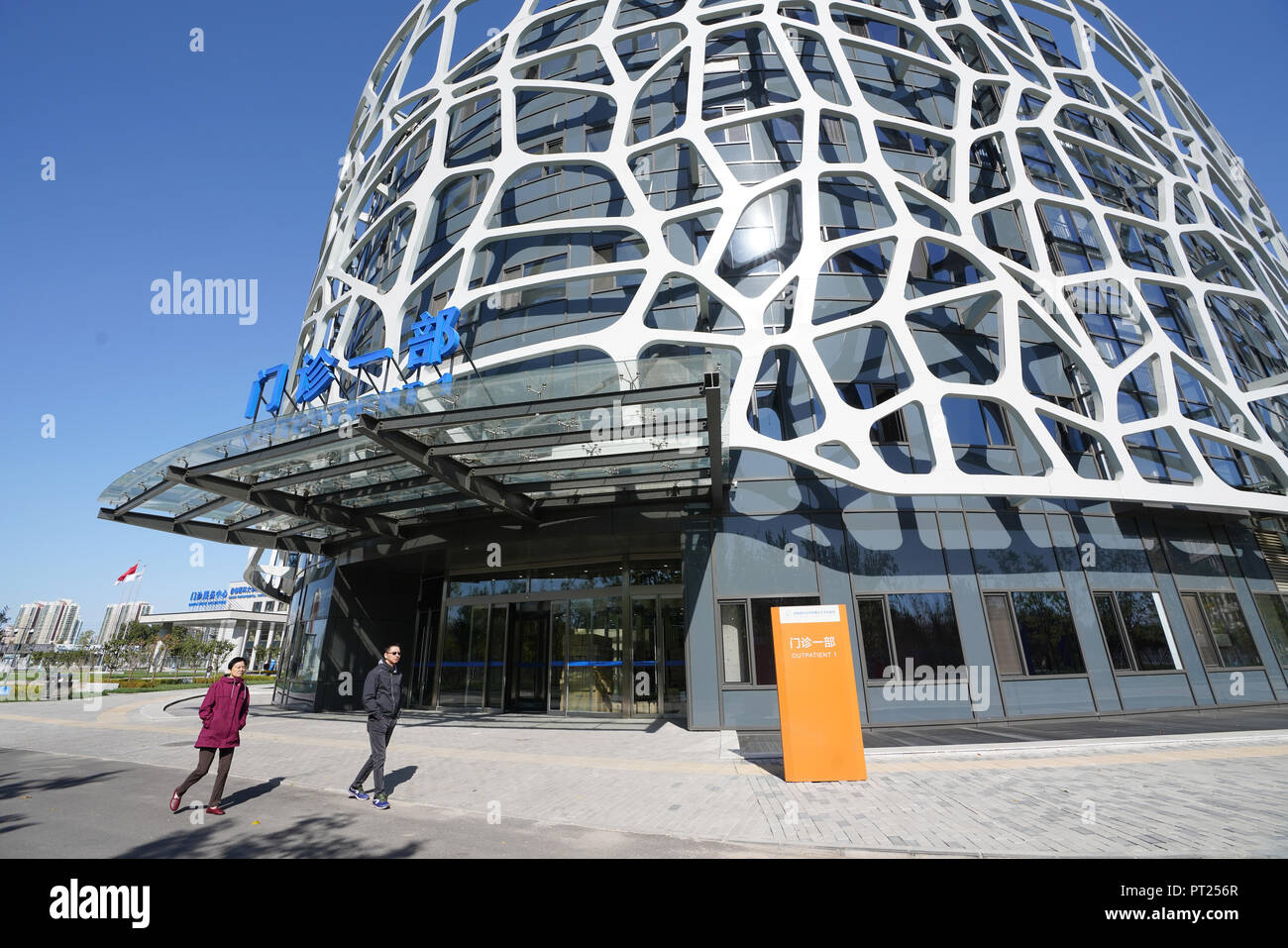 Beijing, China. 6th Oct, 2018. People walk past an outpatient building ...