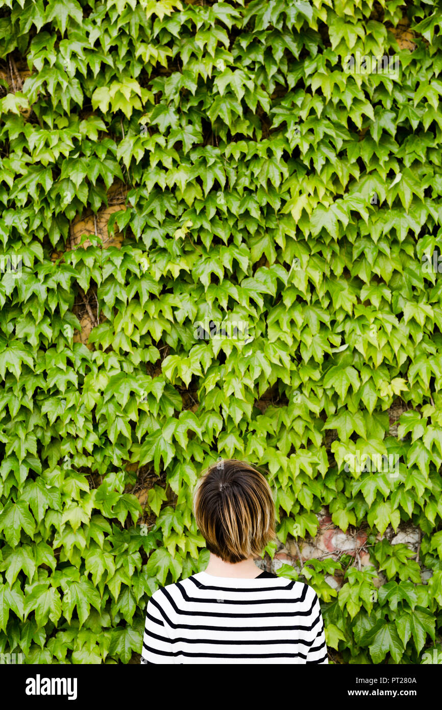 Back view of woman in front of facade greenery Stock Photo - Alamy