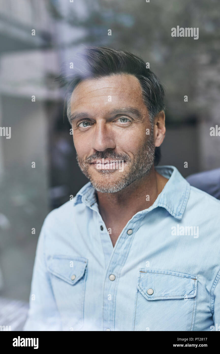 Portrait of smiling man behind windowpane Stock Photo - Alamy