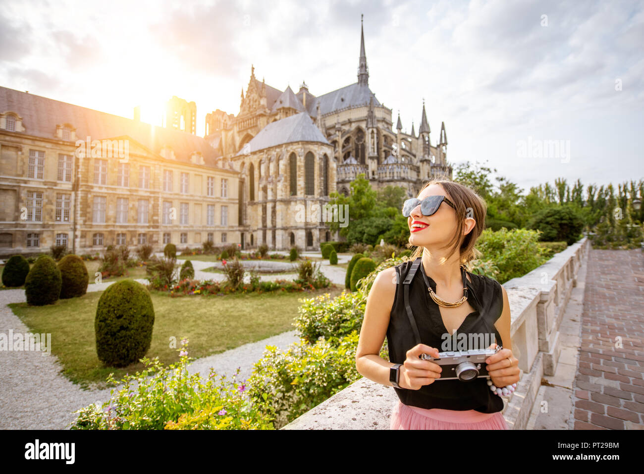 Young woman enjoying beautiful view on the Reims cathedral and gardens ...