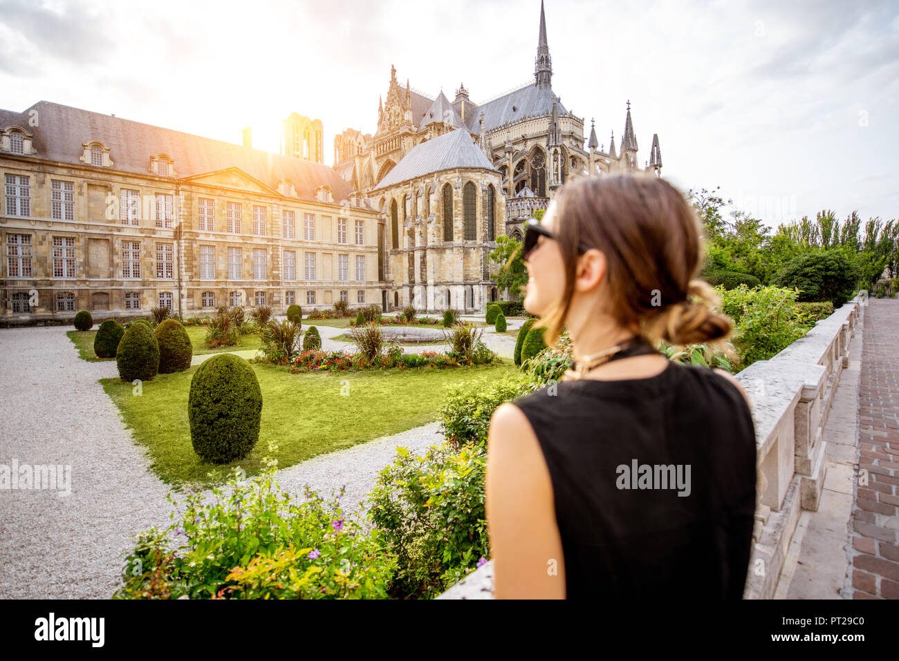 Young woman enjoying beautiful view on the Reims cathedral and gardens ...