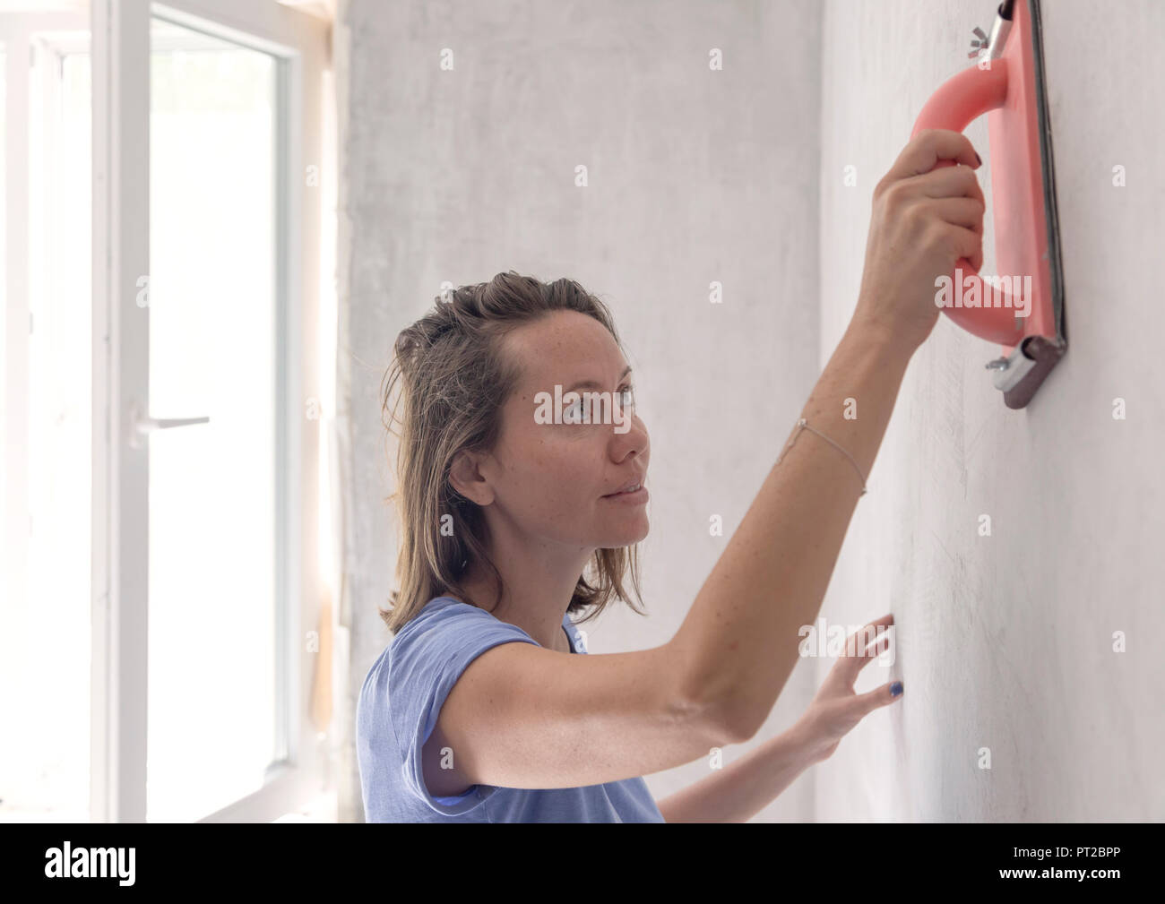 Young woman working rubbing board plaster hi-res stock photography and ...