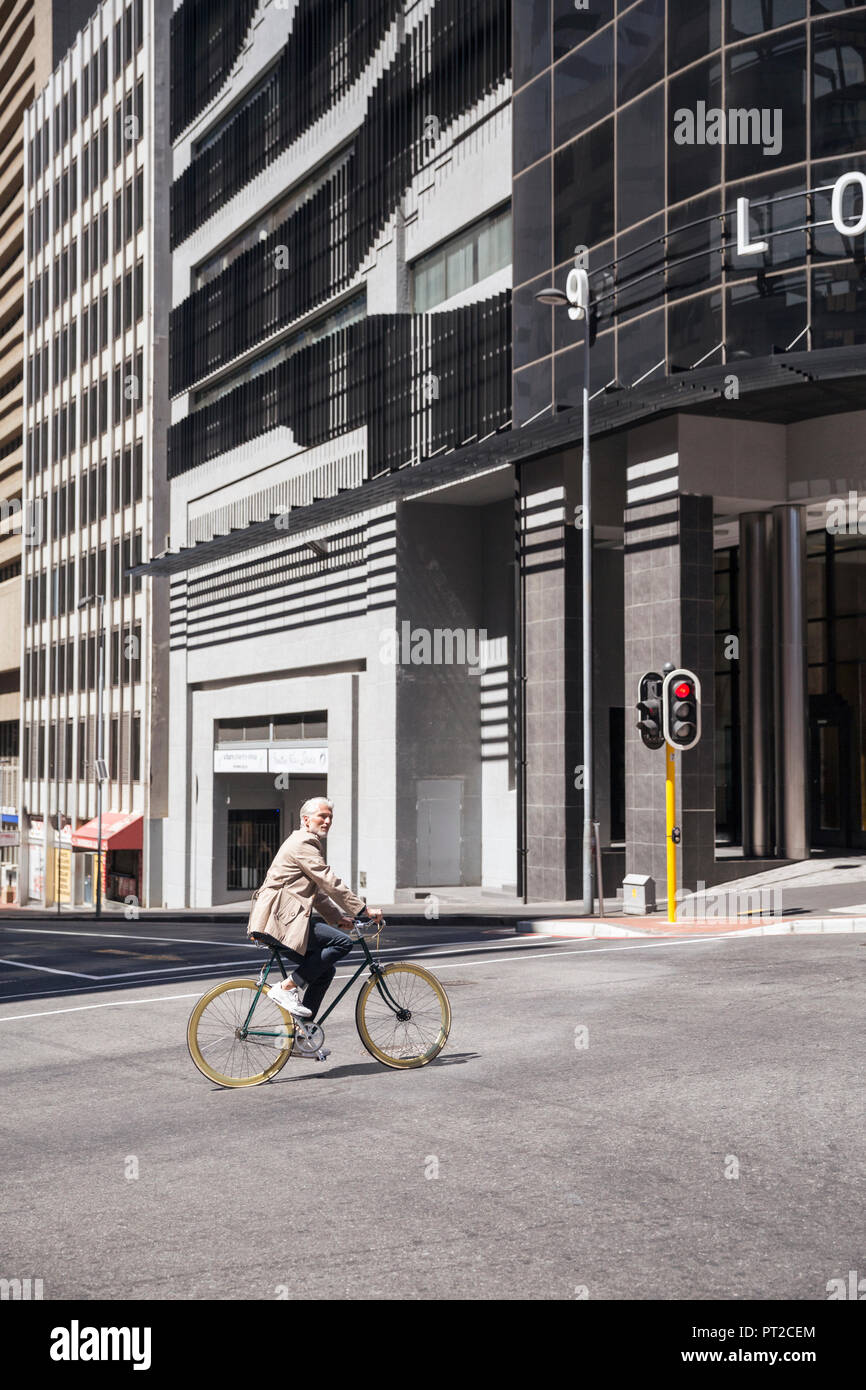 Mature man riding bicycle in the city Stock Photo - Alamy
