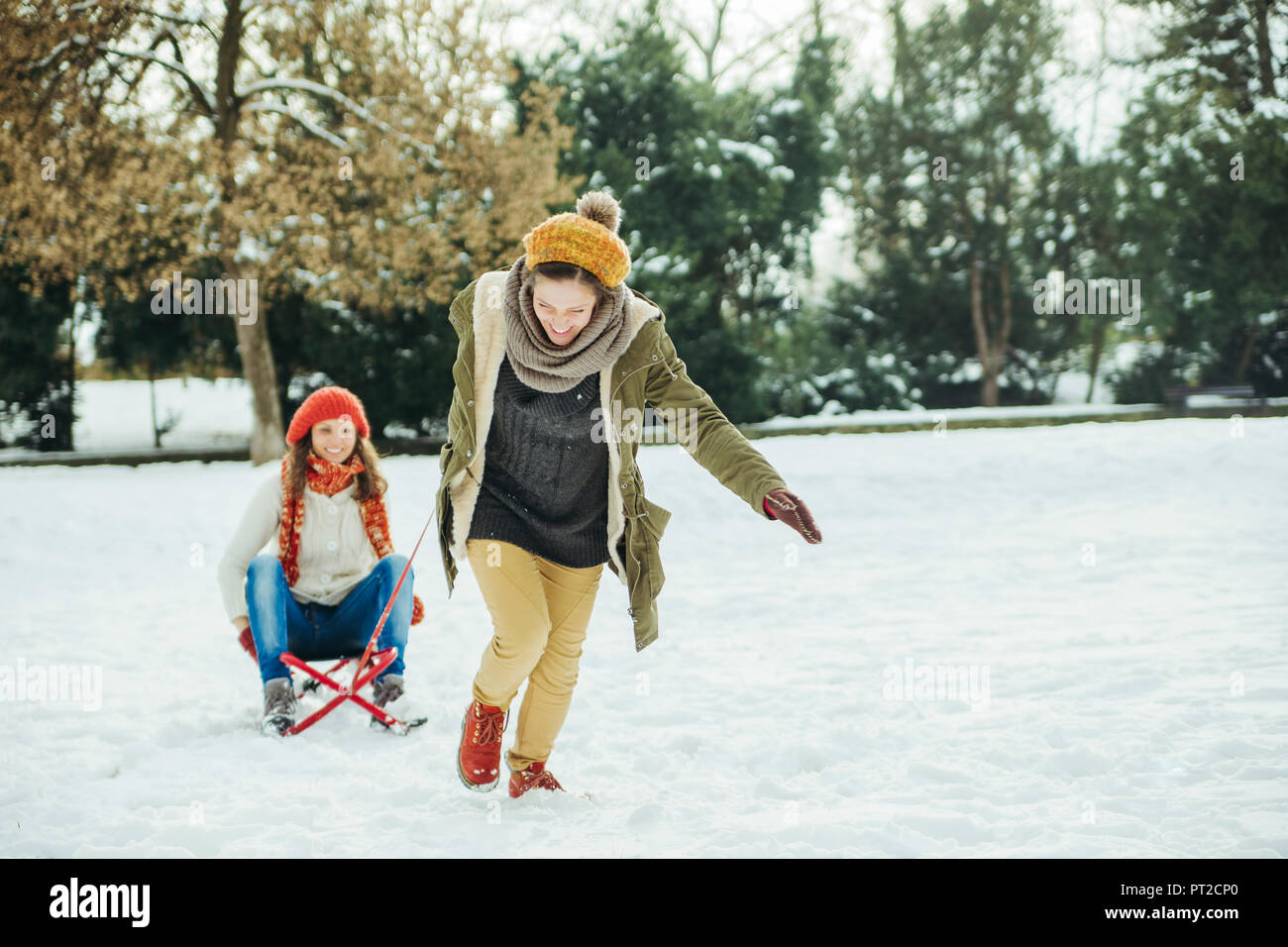 Two friends having fun in the snow Stock Photo - Alamy