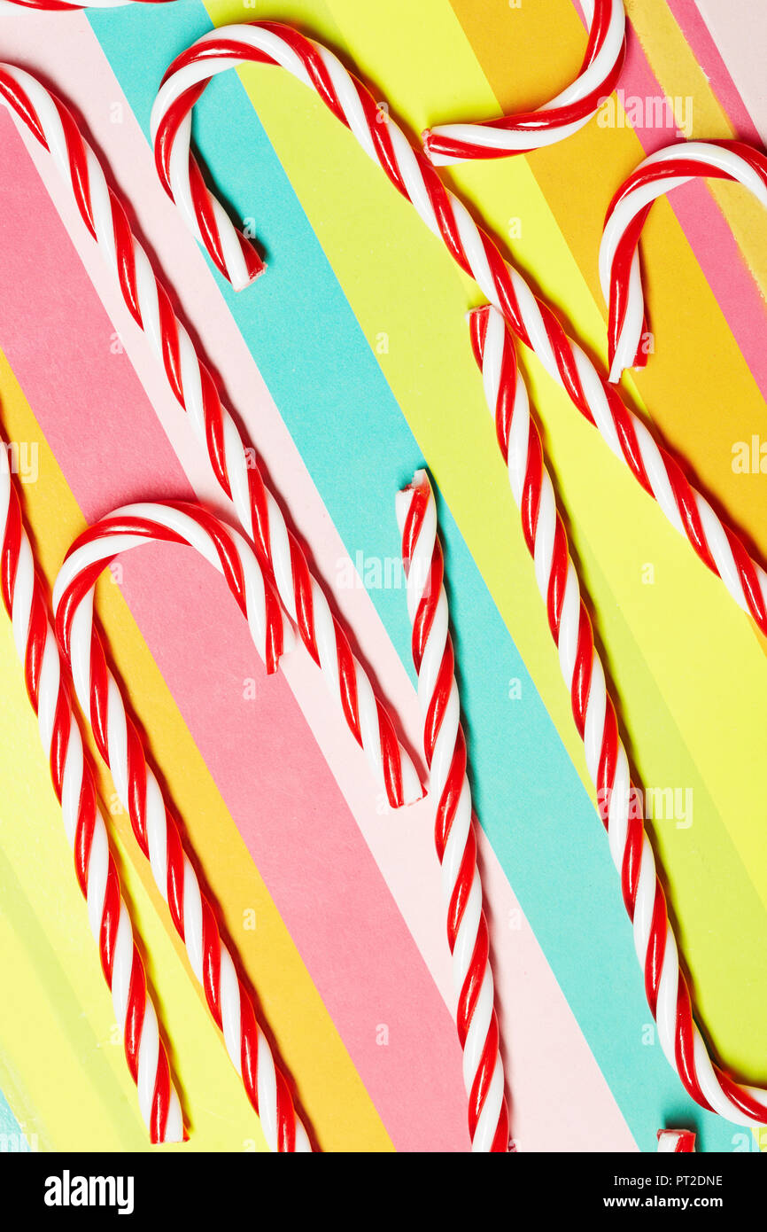 Candy canes on multi-coloured paper Stock Photo - Alamy