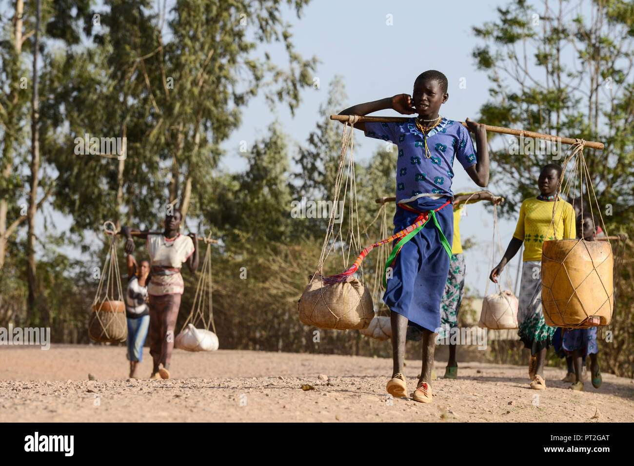 ETHIOPIA Province Benishangul-Gumuz, town Debate, Gumuz women carrying ...
