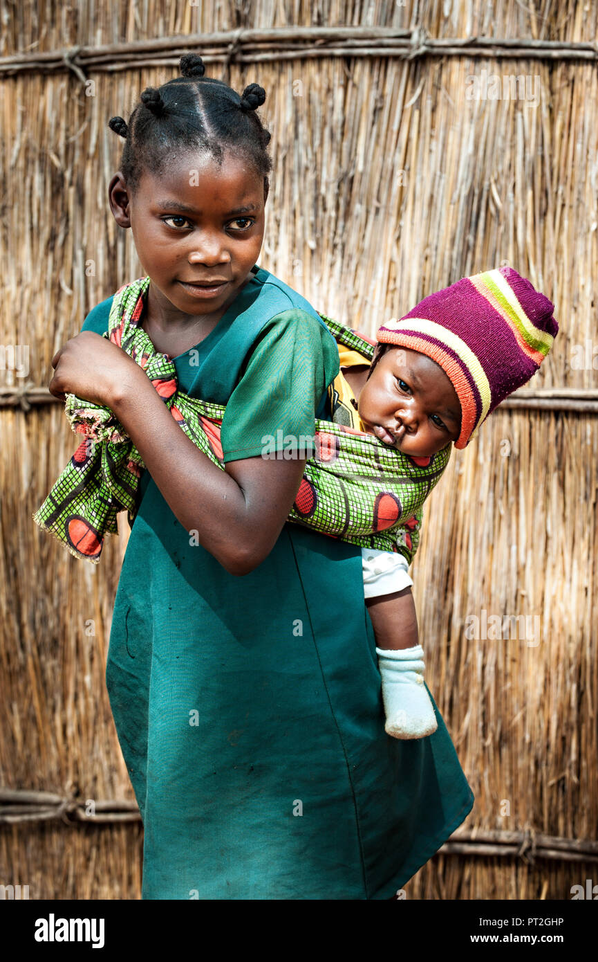 A captivating portrait of a young child mother carrying her baby on her ...