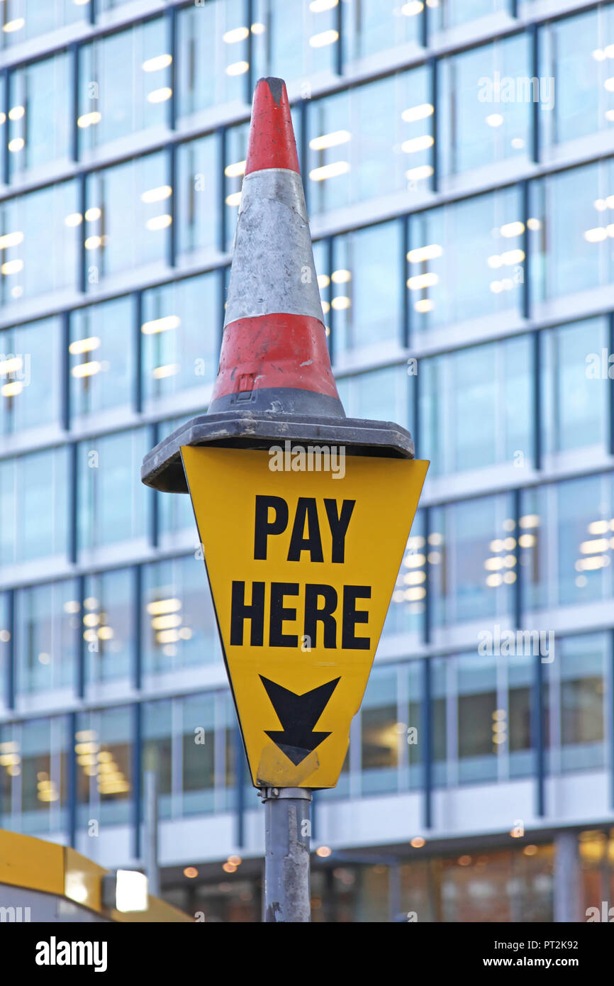 Pay Here Yellow Sign With Traffic Cone Stock Photo - Alamy