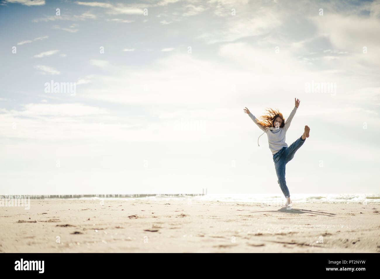 Happy woman having fun at the beach, dancing in the sand Stock Photo ...