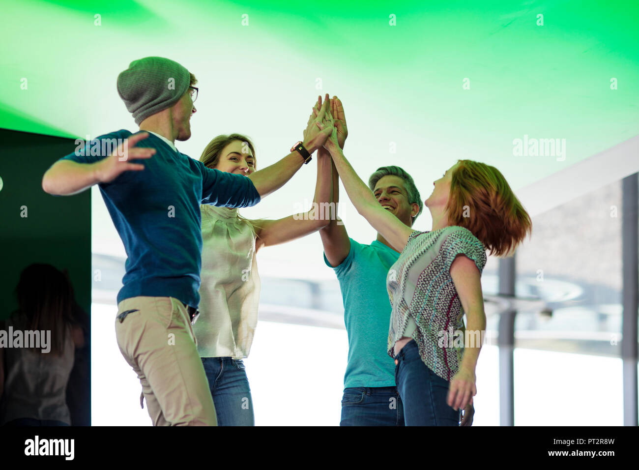 Happy business people high-fiving in office, jumping for joy Stock ...