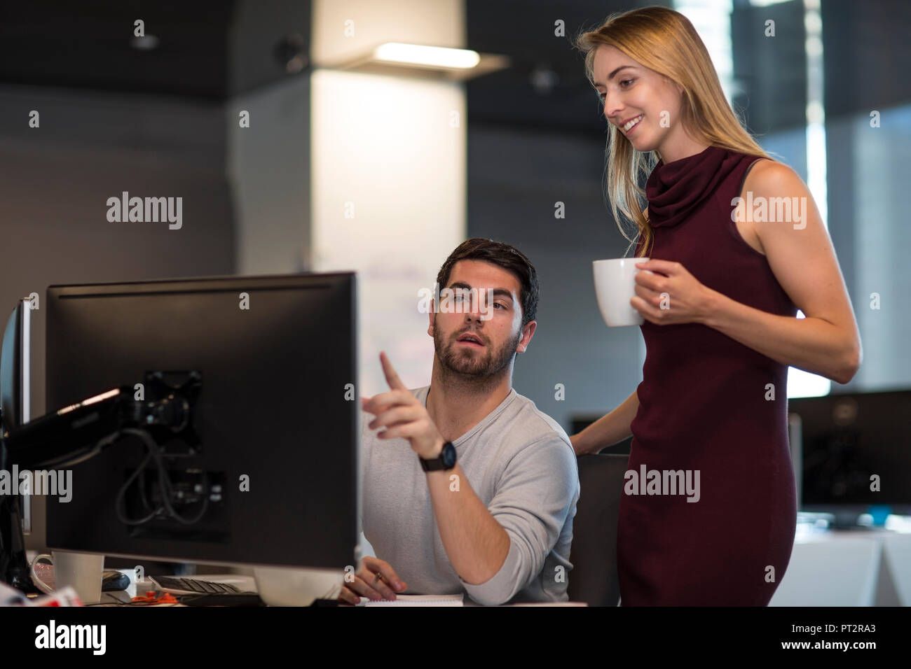 Colleagues discussing in front of computer Stock Photo - Alamy