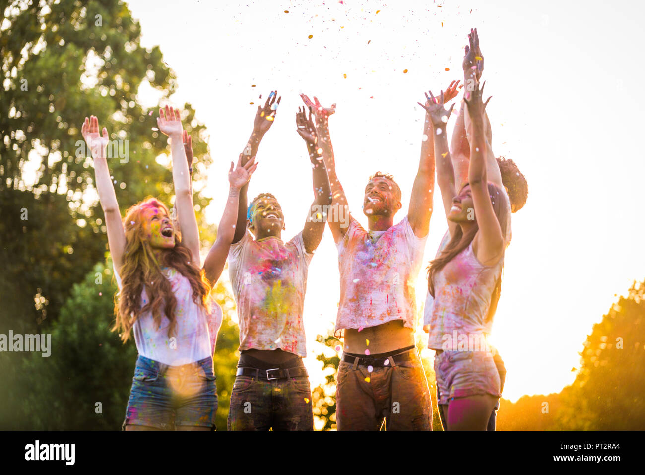 Group of happy friends playing with holi colors in a park - Young ...