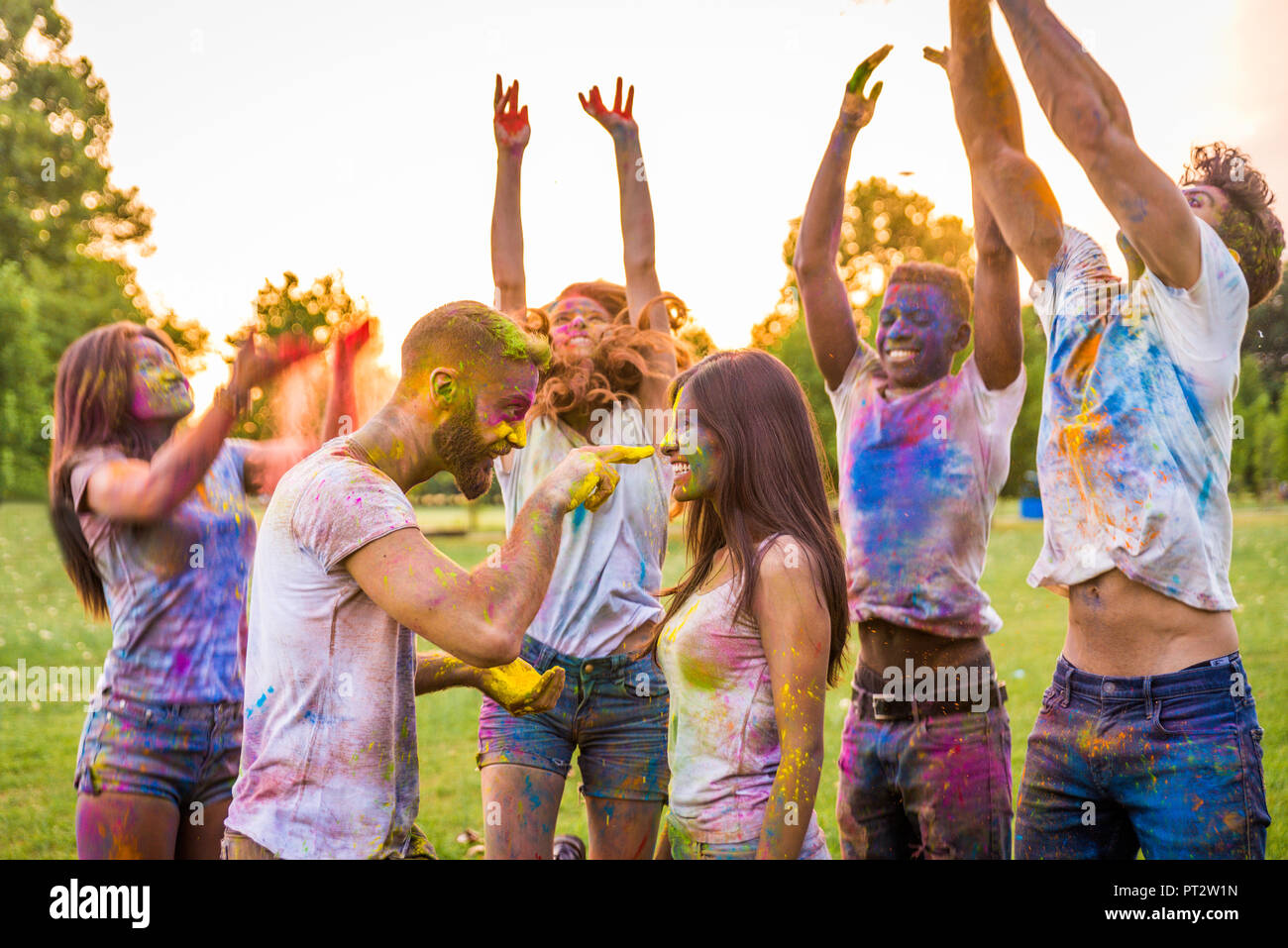 Group of happy friends playing with holi colors in a park - Young ...
