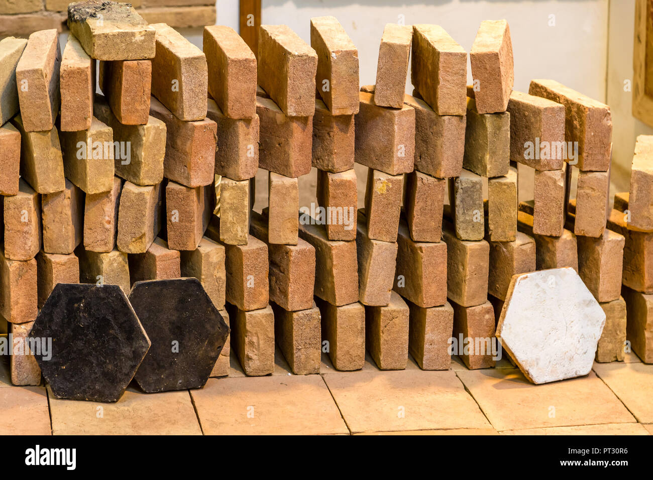 Hexagonal tiles on a background of Stacked Bricks Stock Photo - Alamy