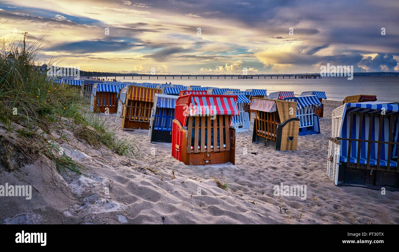 Evening sun with low light on beach filled with traditional wicker ...