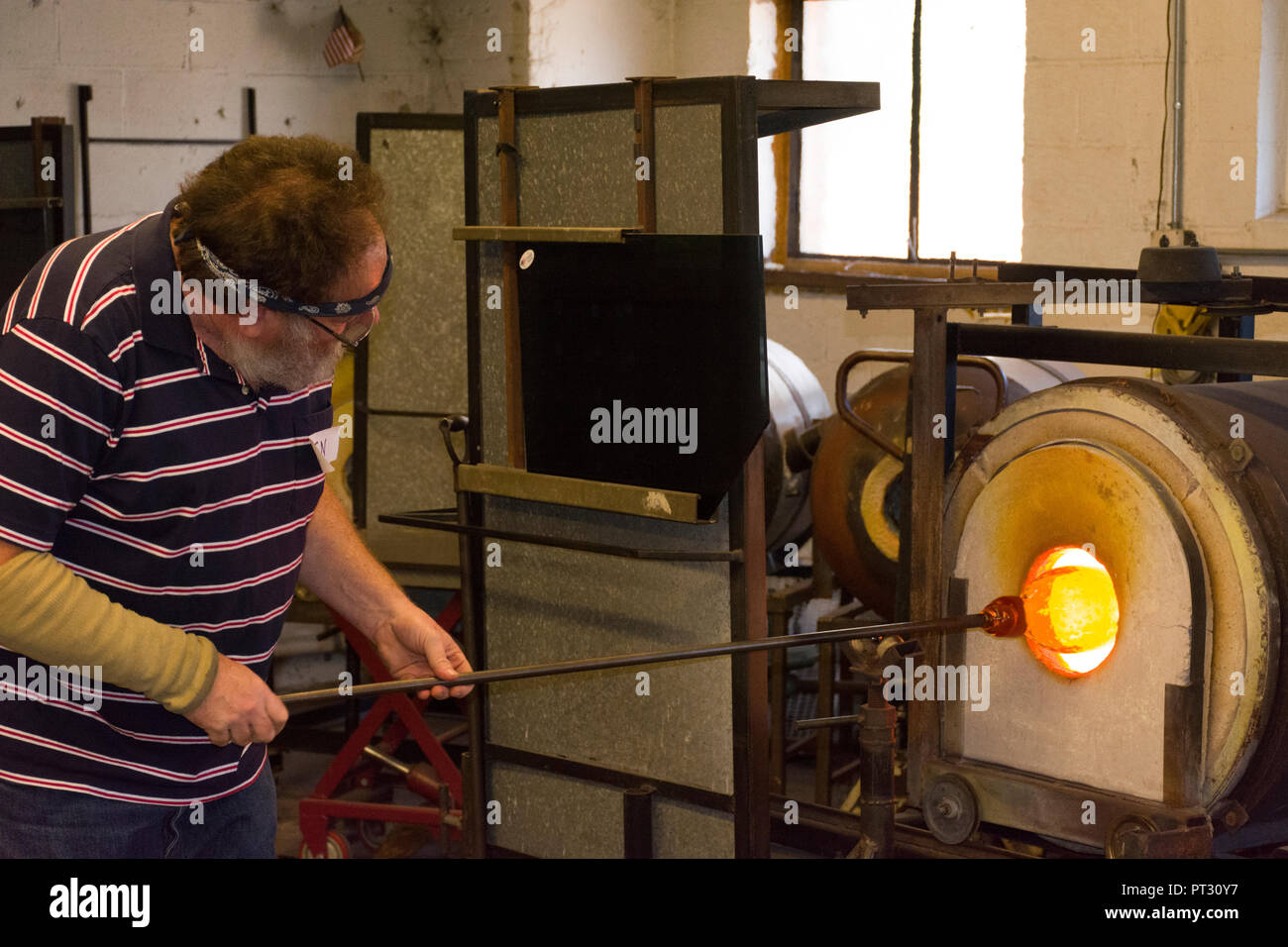 Cambridge, MA. Glass blower at a workshop/school for glass blowing ...