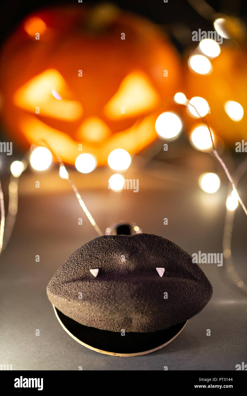 Black lips with vampire fangs. Halloween scary mousse cake with pumpkin ...