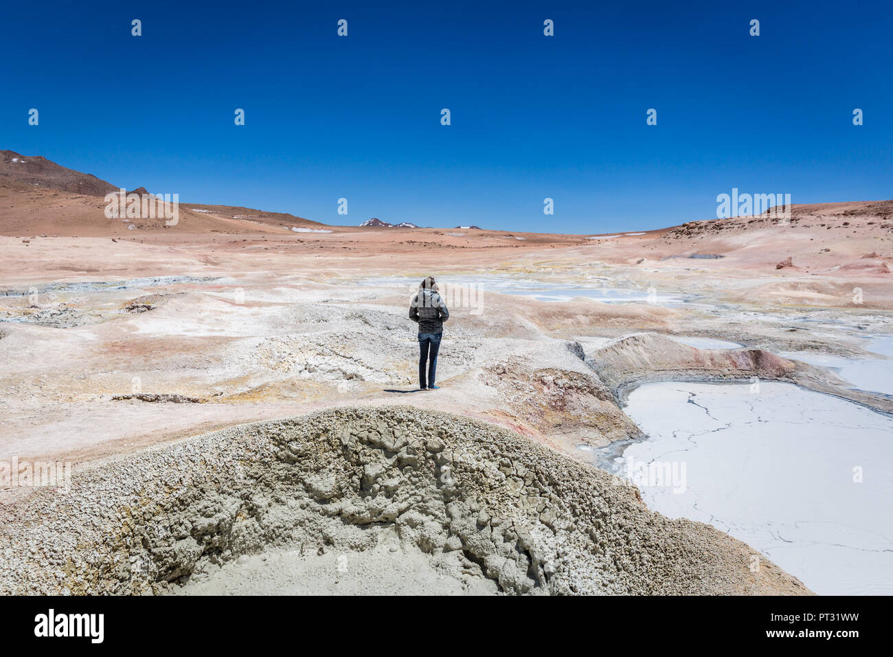 Young woman enjoying the amazing geyser of the Bolivia Altiplano ...