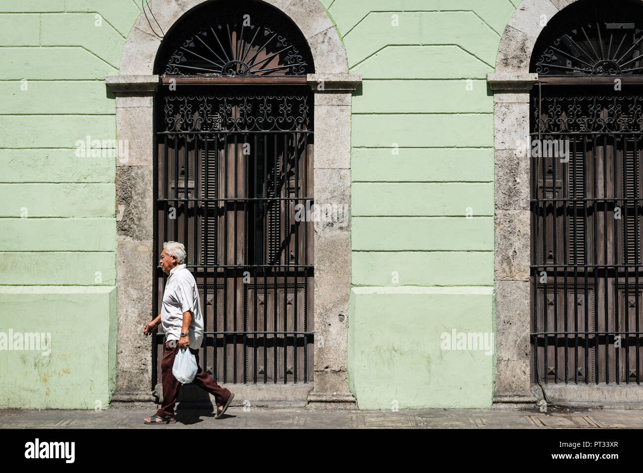 Man walking past a Colonial style building in Merida, Mexico Stock ...