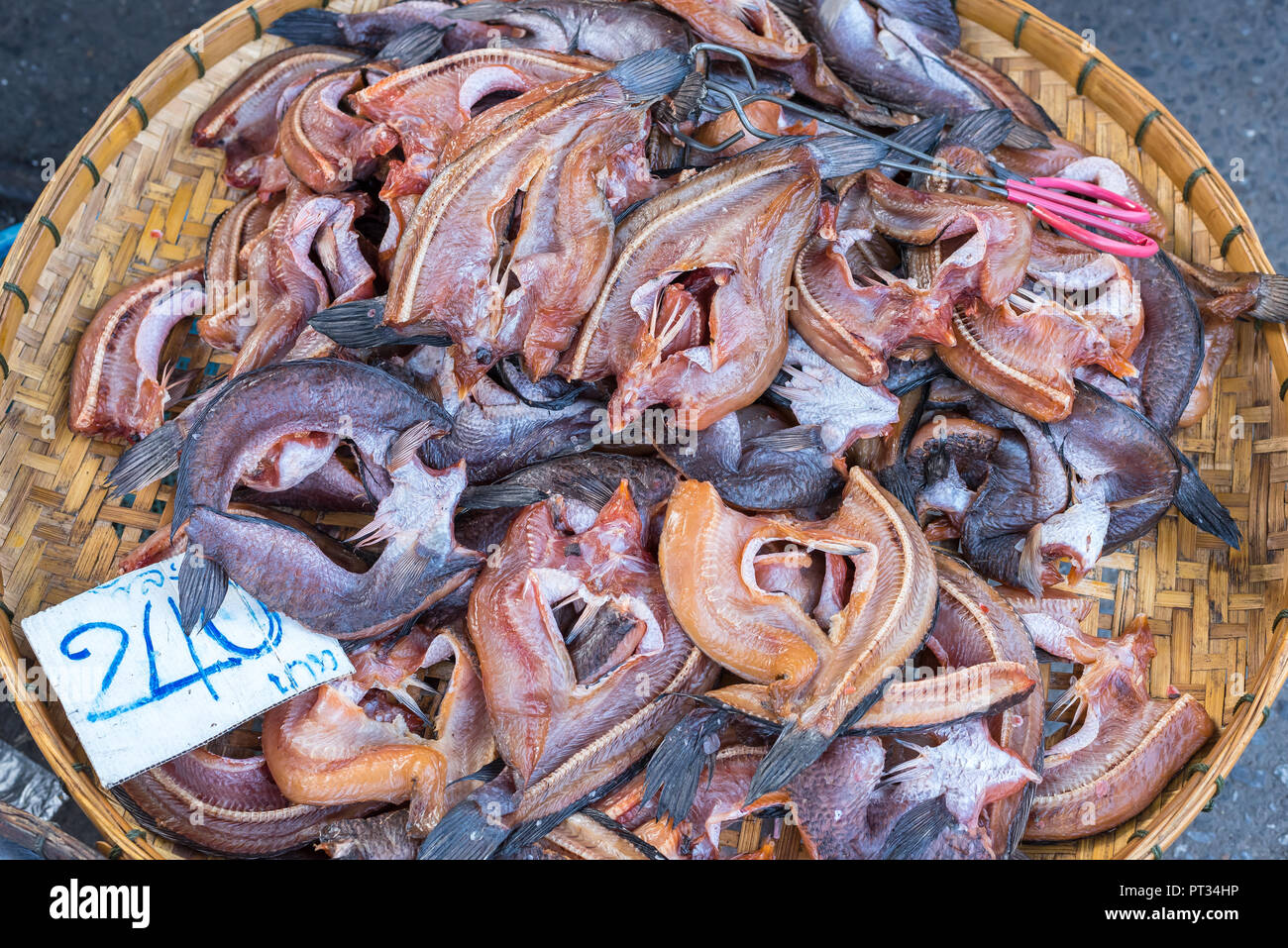 Sun dried fish in the round bamboo tray being sold in a fresh market ...