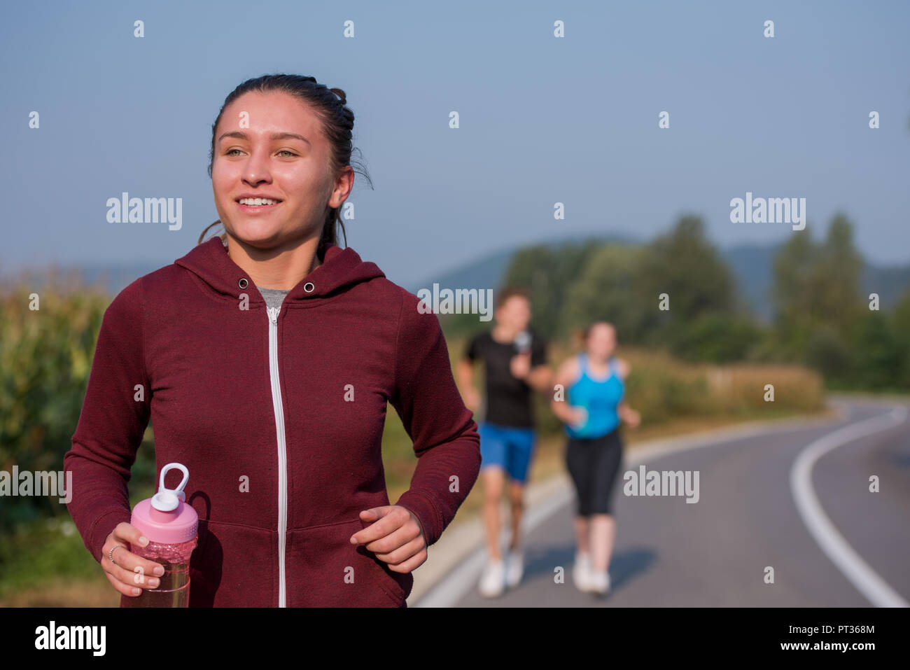 group of young people jogging on country road runners running on open ...