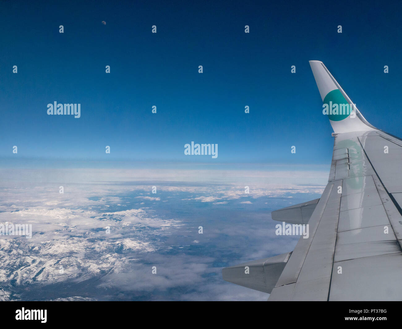 Looking out an airplane window, with blue sky and mountain range Stock ...