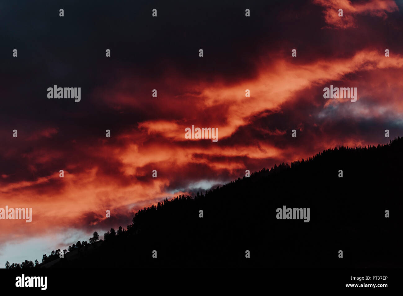 Mountain slope in red evening sun with clouds, blue red clouds Stock ...