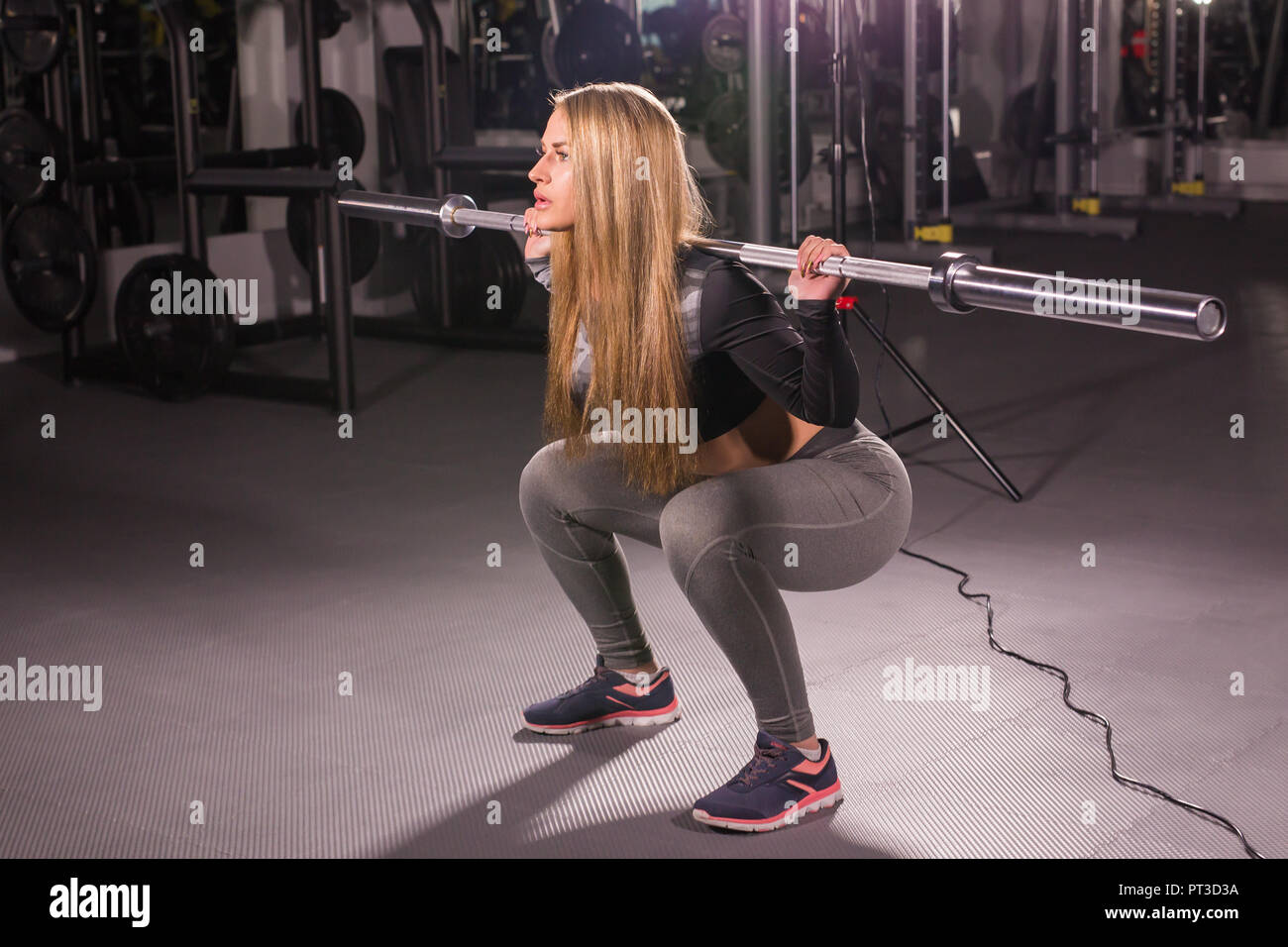 Pretty woman working out with barbell in a gym Stock Photo - Alamy