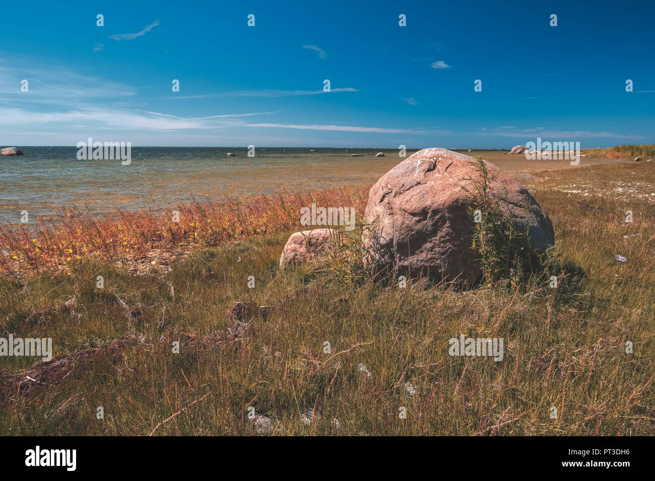rocky sea beach with wide angle perspective over the sea with sunny sky ...
