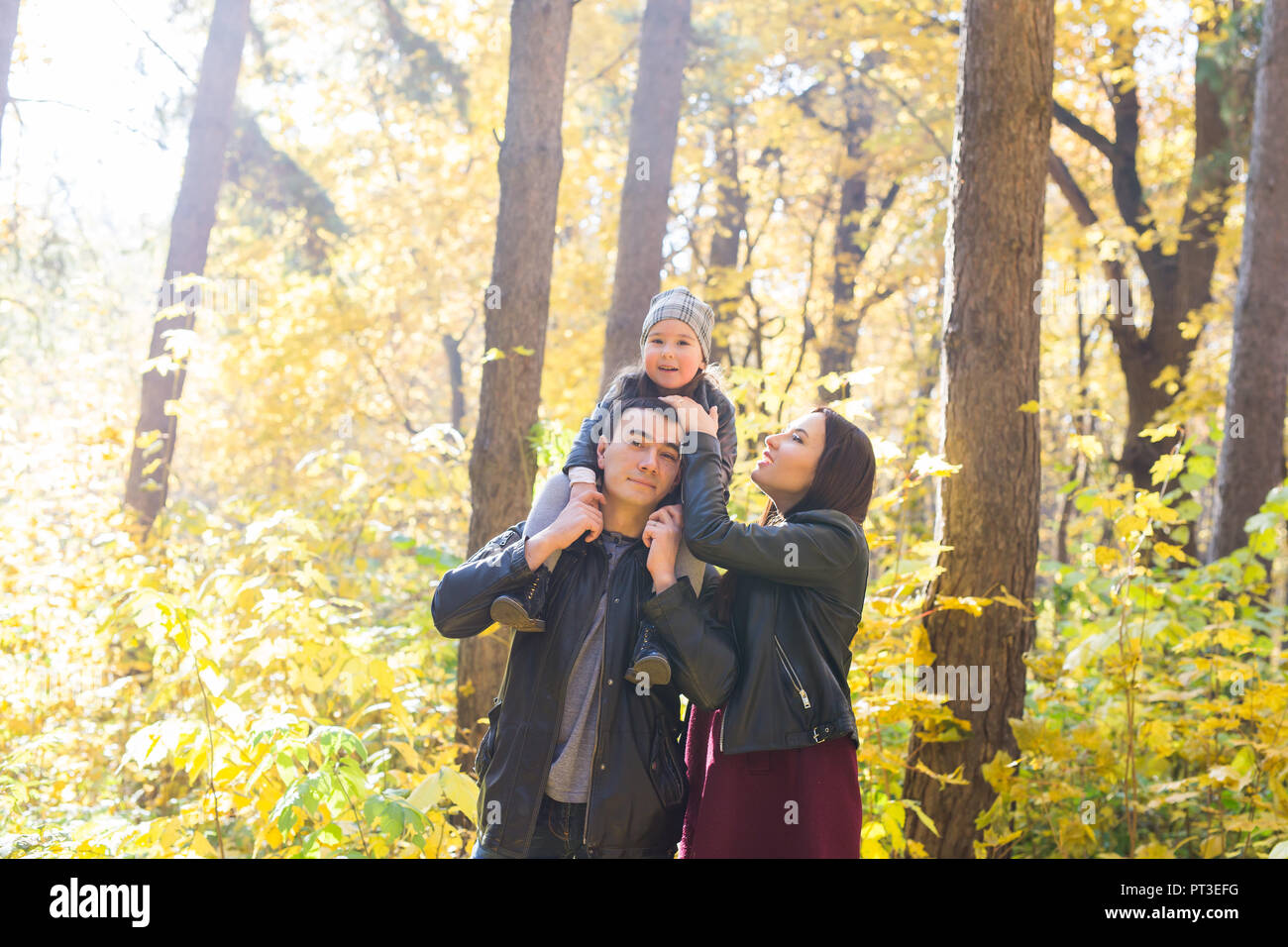 Family, fall, people concept - young family walking in park in autumn ...