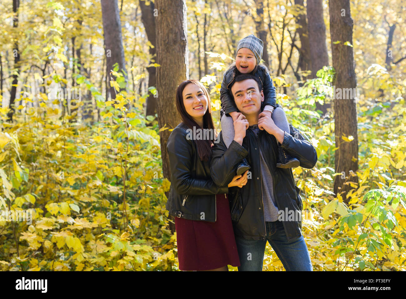 Family, autumn, people concept - young family walking in autumn park ...