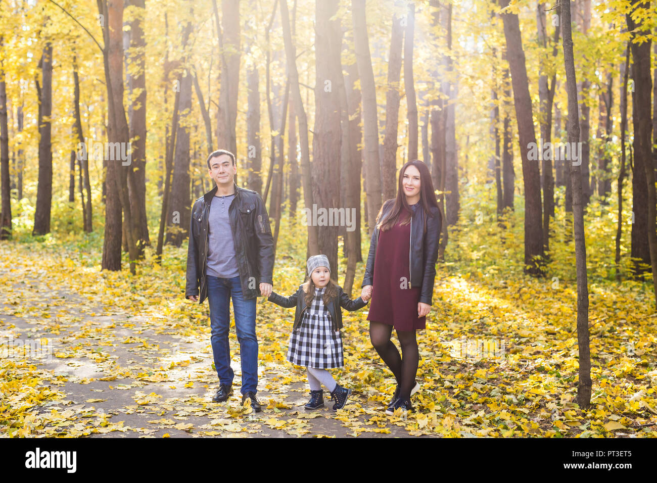 Family, fall, people concept - mixed race young family walking in park ...