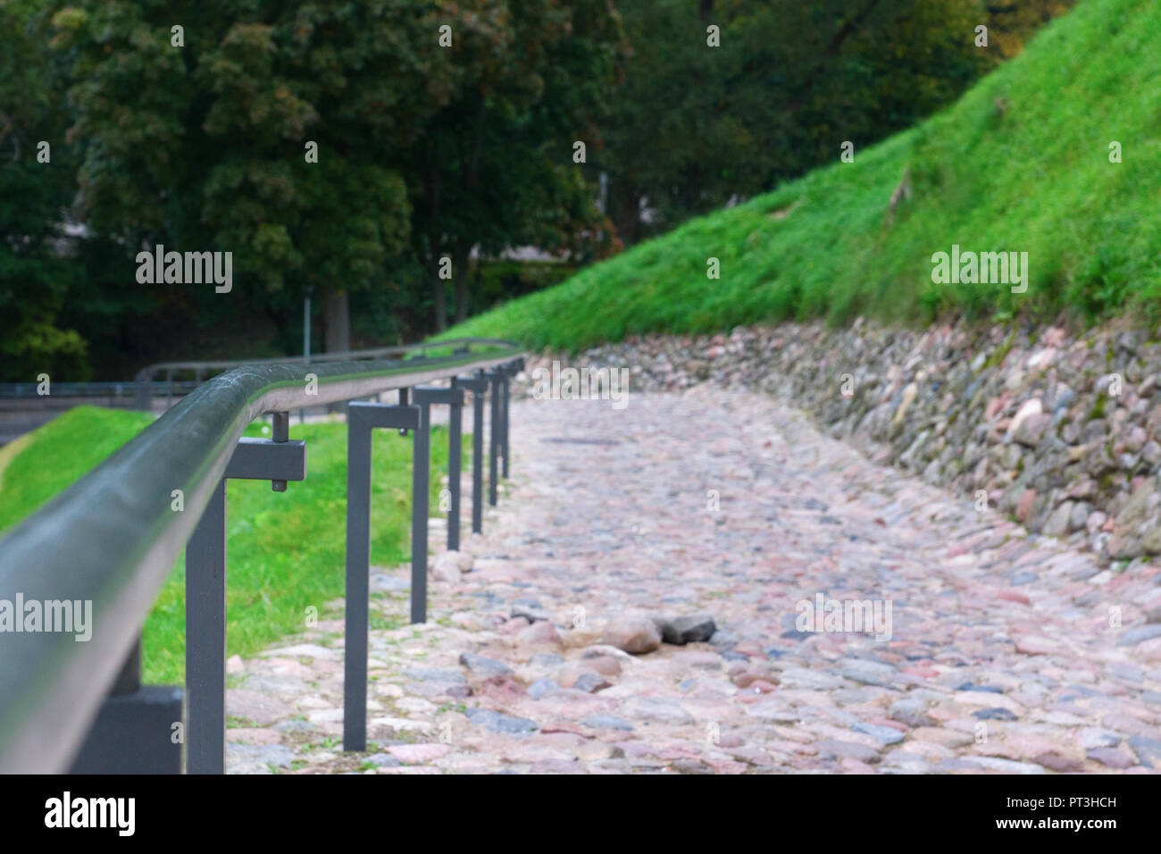 metal railings are located along the paved road Stock Photo - Alamy