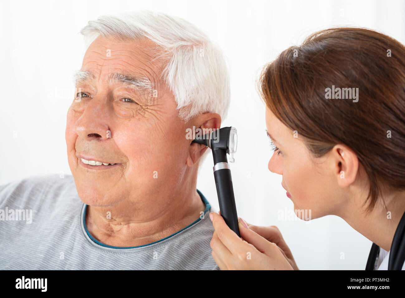Close-up Of A Female Doctor Examining Senior Male Patient's Ear With ...